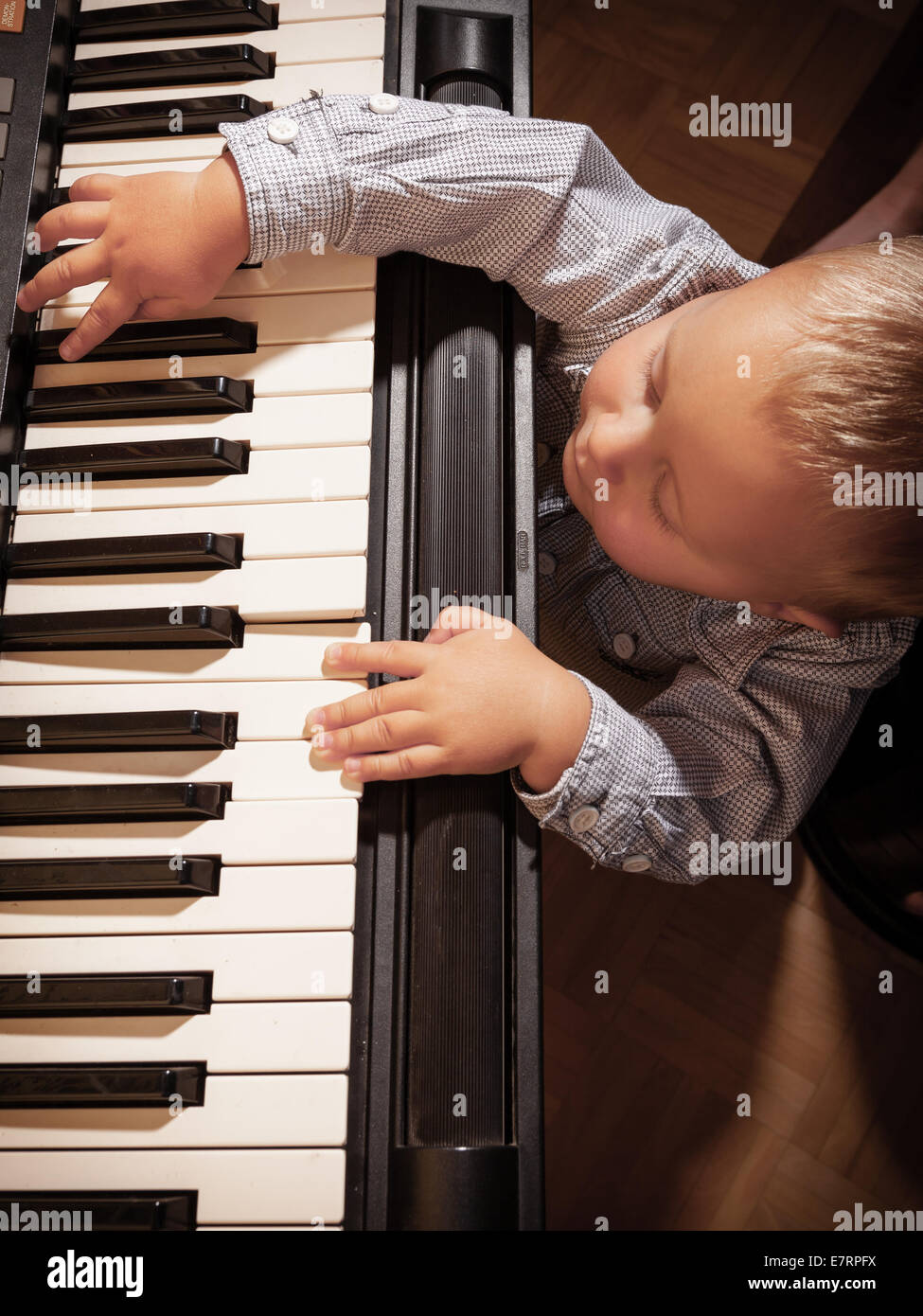 Happy childhood and music. Little boy child kid playing on the black ...