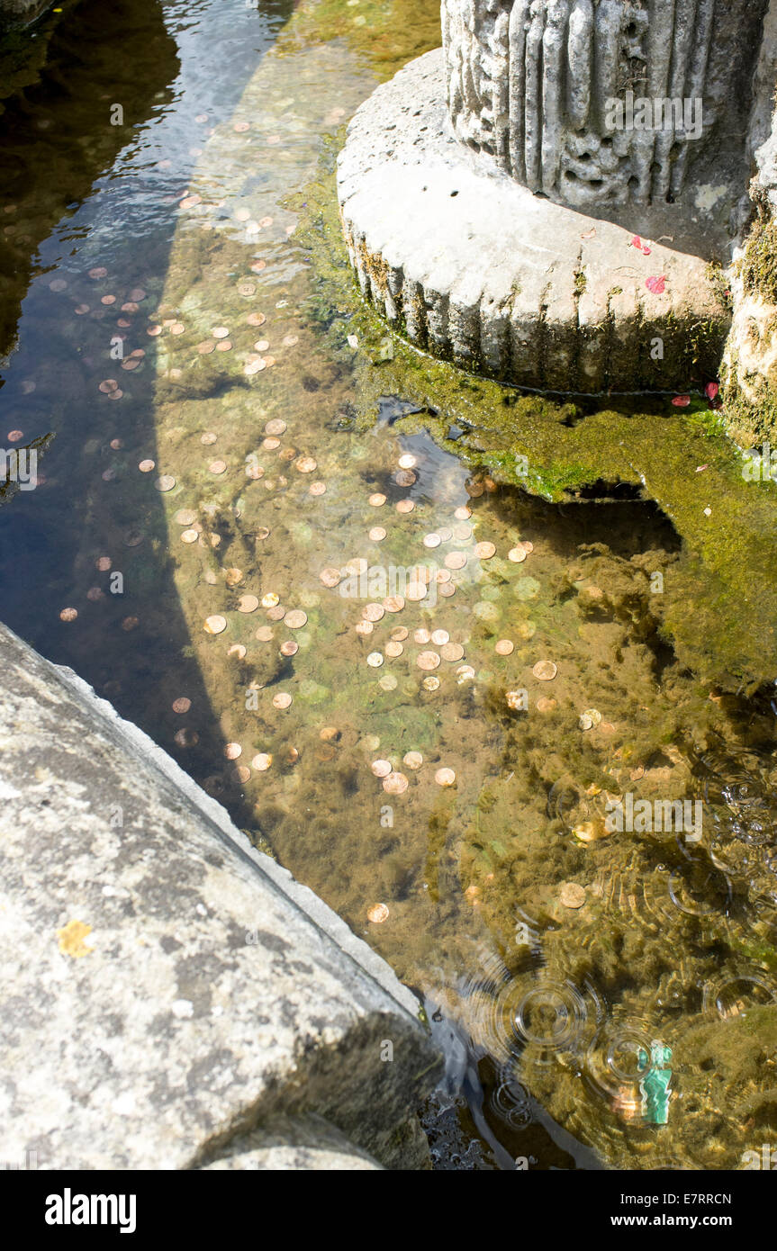 Coins at the bottom of a UK charity wishing well Stock Photo - Alamy