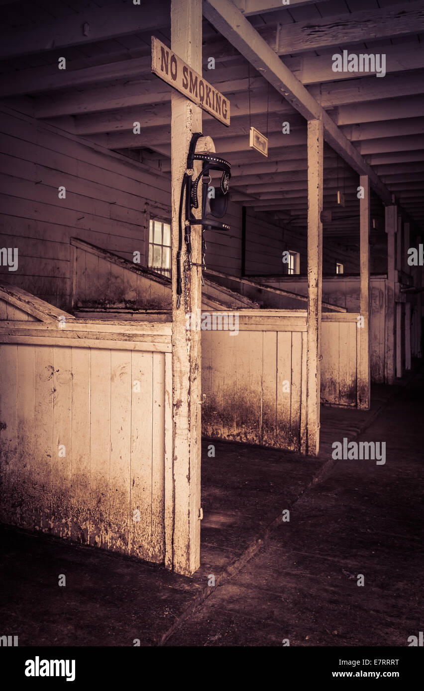 Dimly lit inside of an empty old horse barn on a turn of the century ...