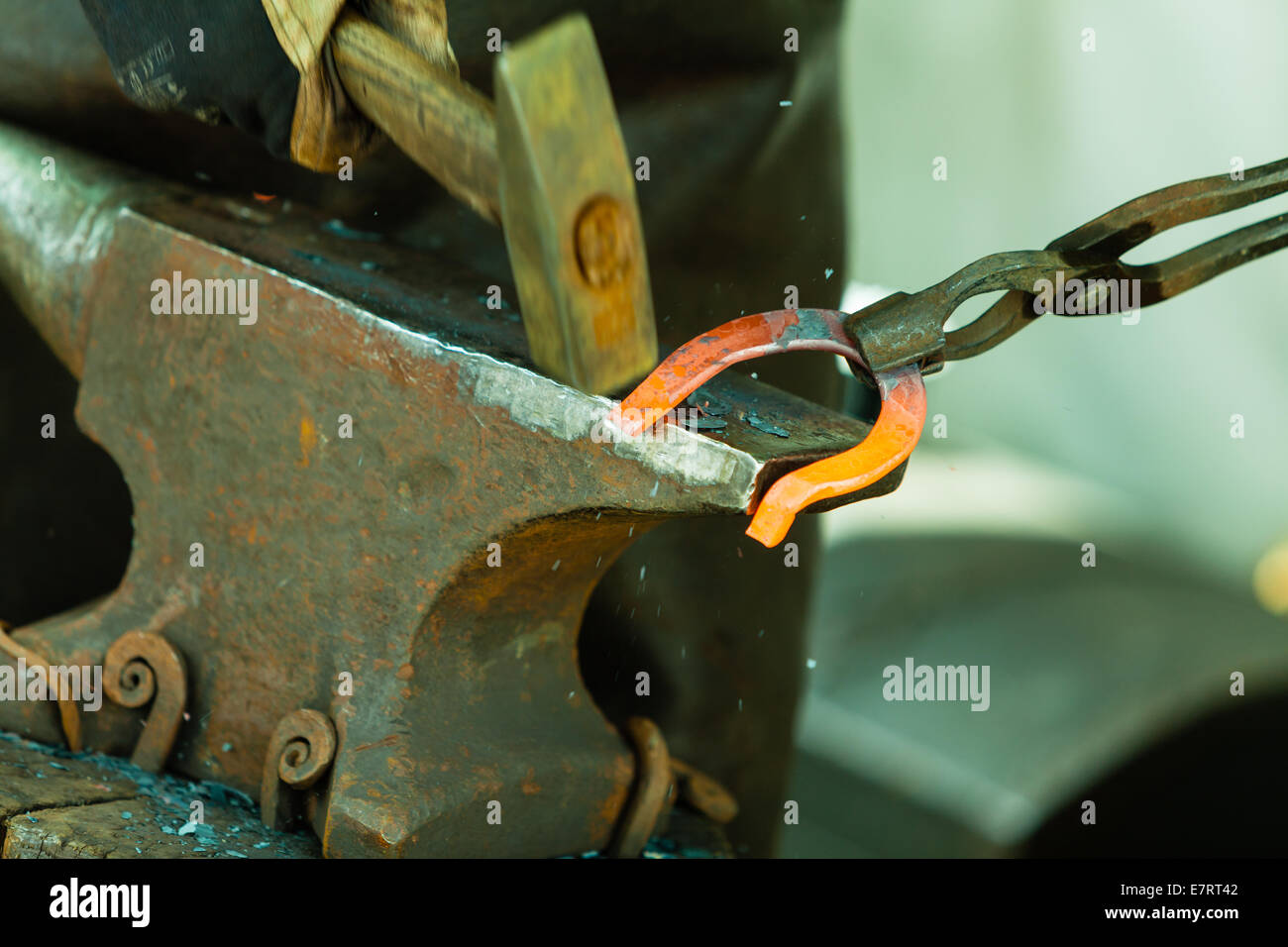 Making decorative element in the smithy on the anvil. Hammering glowing ...