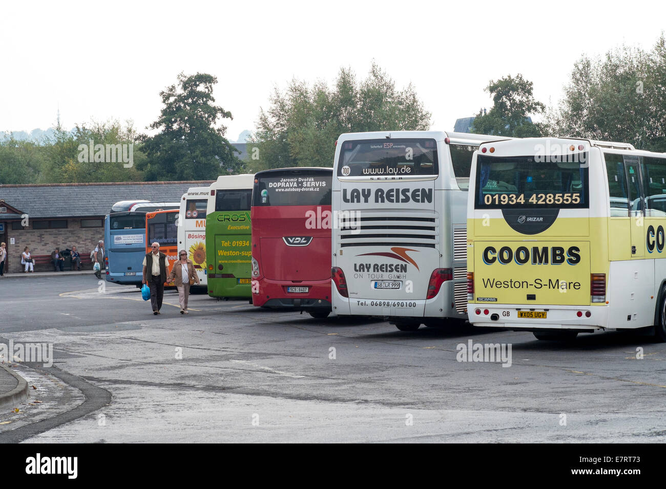 People walking through tour bus station Stock Photo - Alamy
