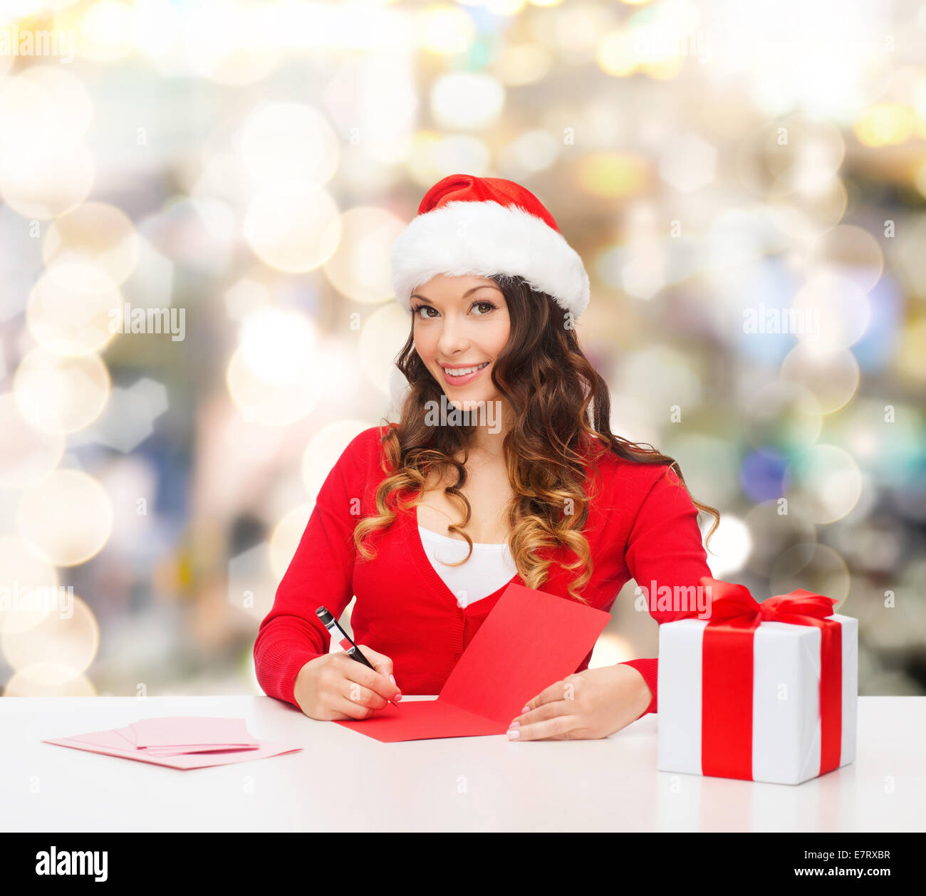 smiling woman with gift box writing letter Stock Photo - Alamy