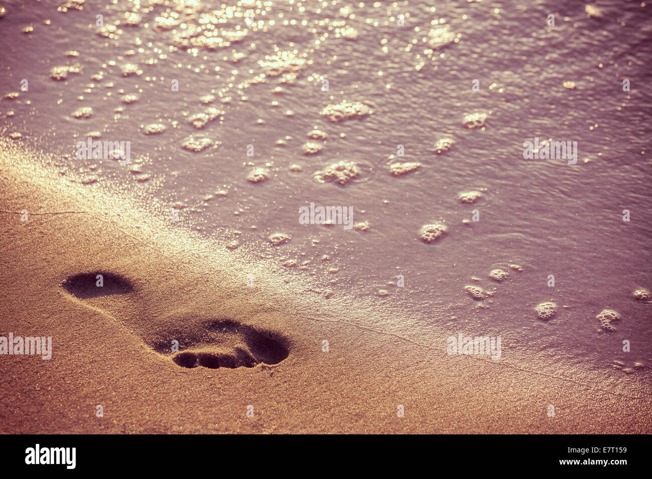 Retro picture of beach, water and footstep at sunset Stock Photo - Alamy