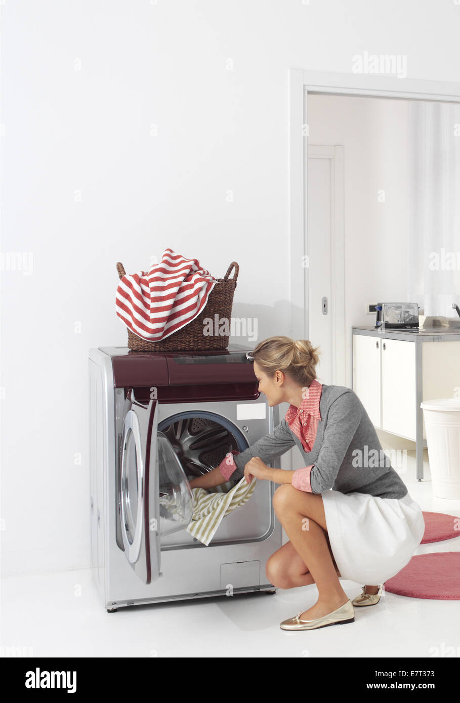 smiling woman dooing laundry with washing machine Stock Photo - Alamy