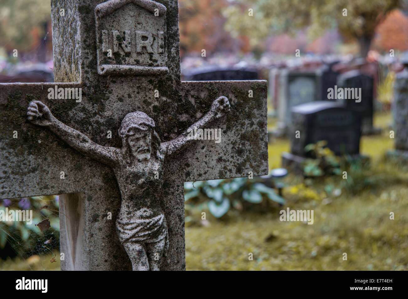 Christ on a cross facing hundreds of tombstones on a graveyard in Fall ...