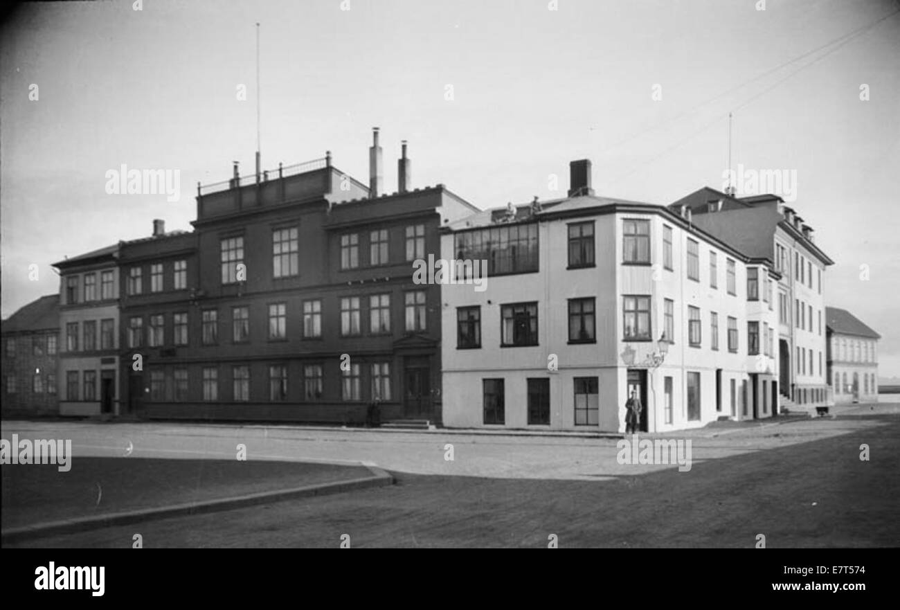 This image shows an urban street scene from the early 20th century in a ...