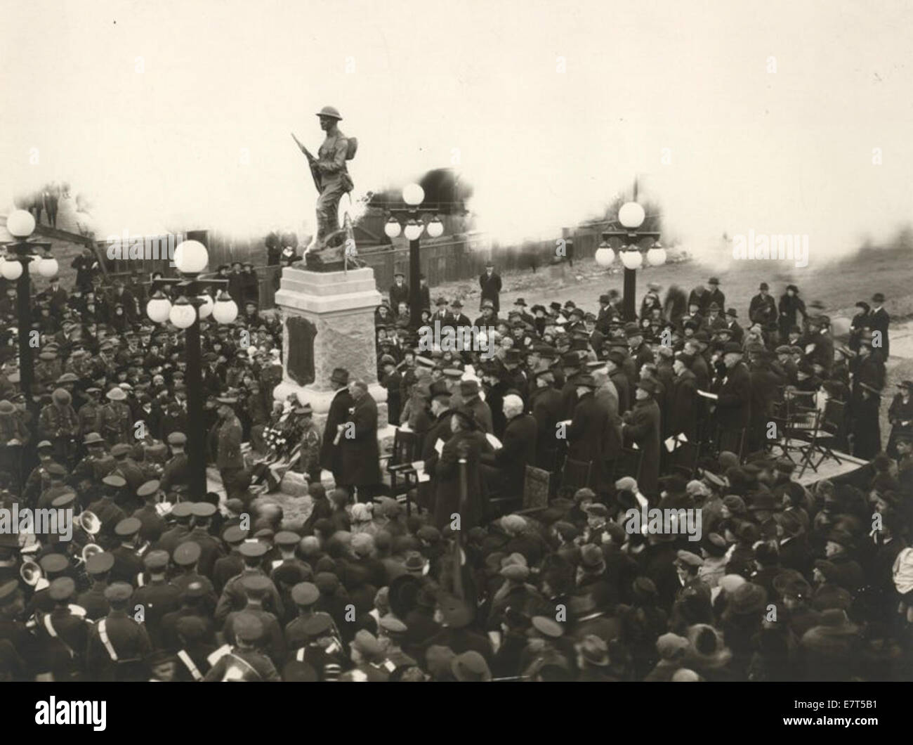 This photograph shows a Remembrance Day ceremony at a war memorial, a ...