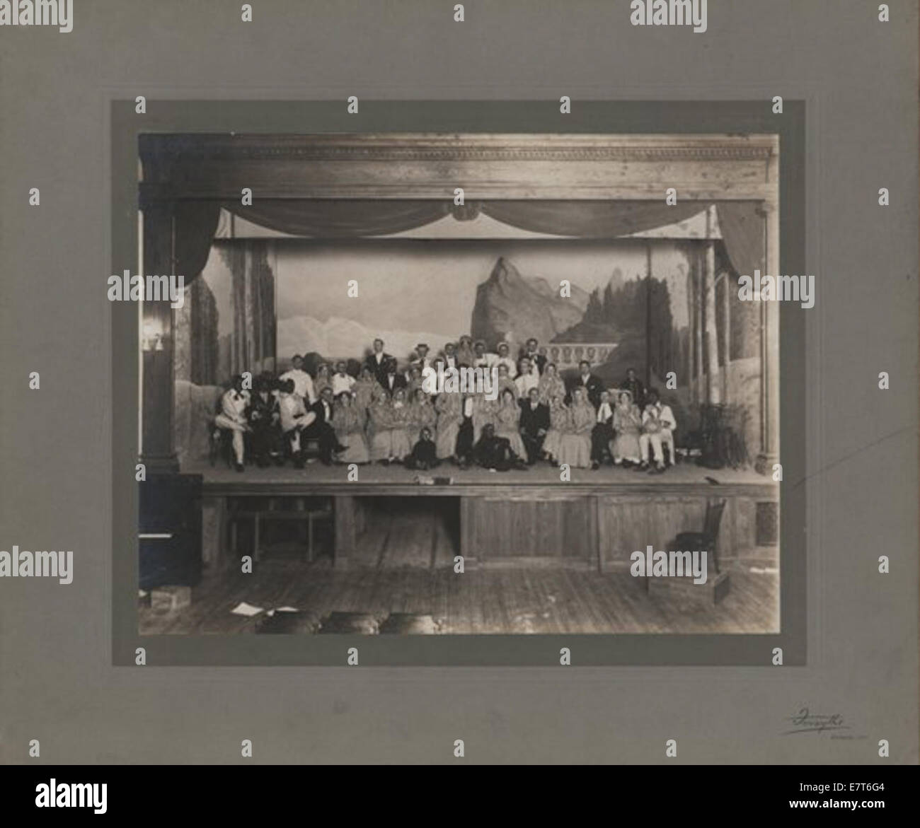 A photograph of the cast of a play, likely taken during a performance ...
