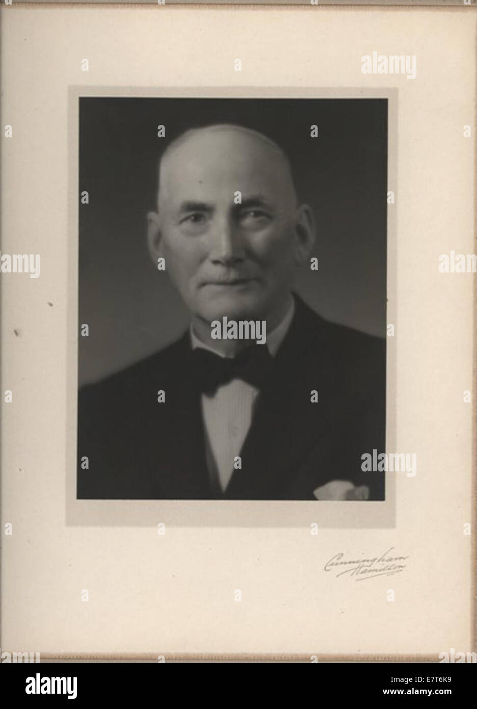 This image presents a formal portrait of an individual, captured in a ...