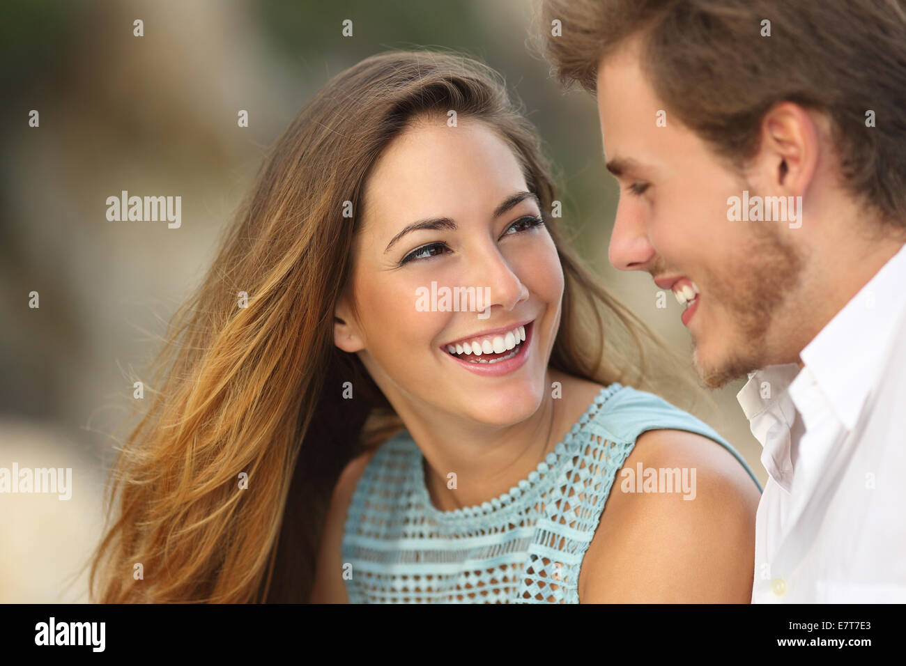 Funny couple laughing with a white perfect smile and looking each other ...