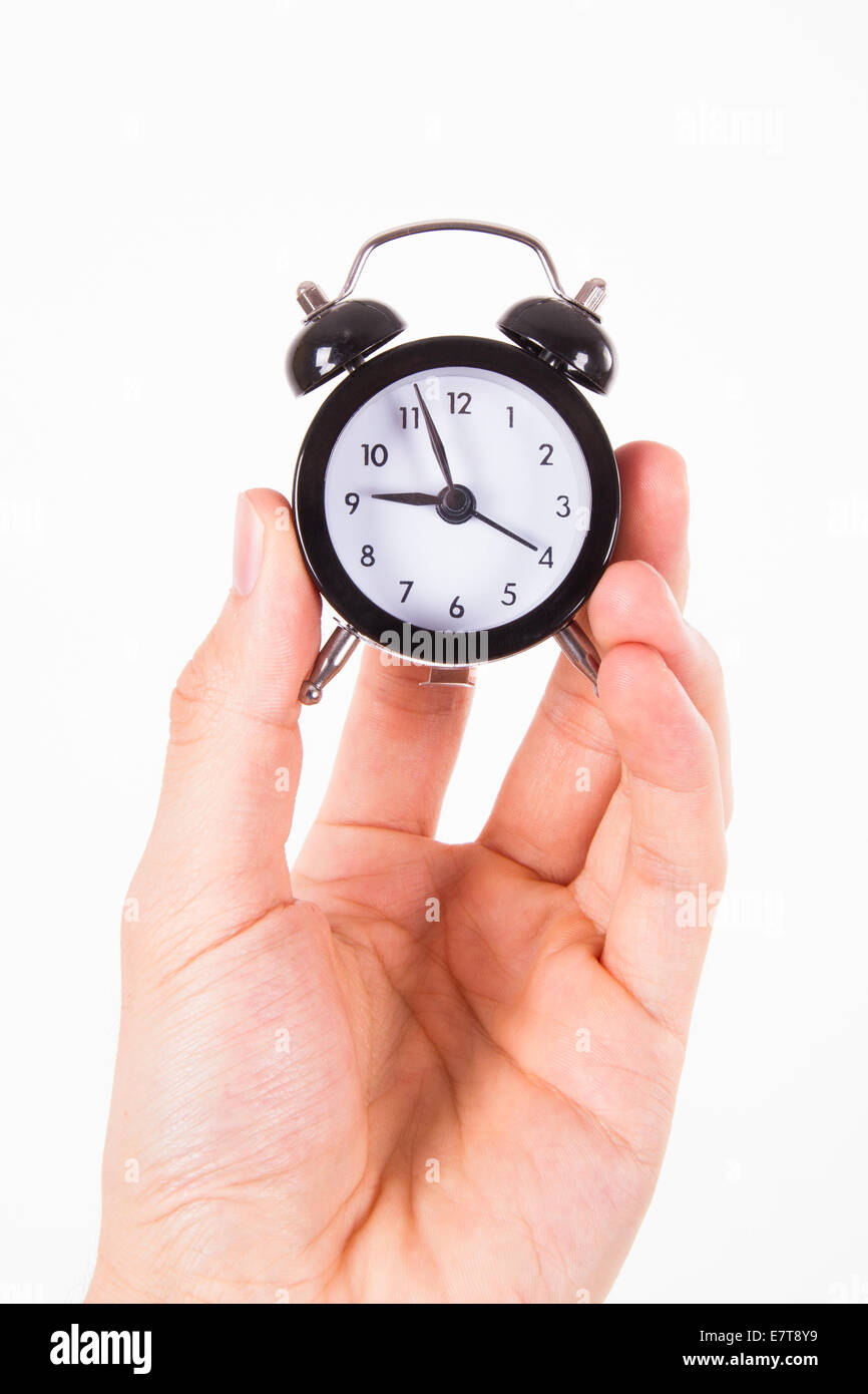 Hand holding old style retro alarm clock with black frame, isolated on ...