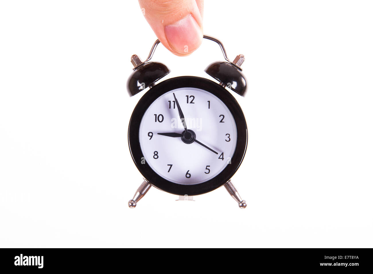 Hand holding old style retro alarm clock with black frame, isolated on ...