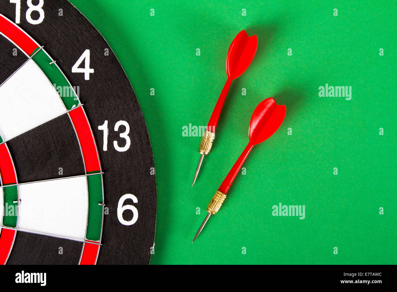 Dart board with black and white sections and red, plastic arrows on ...