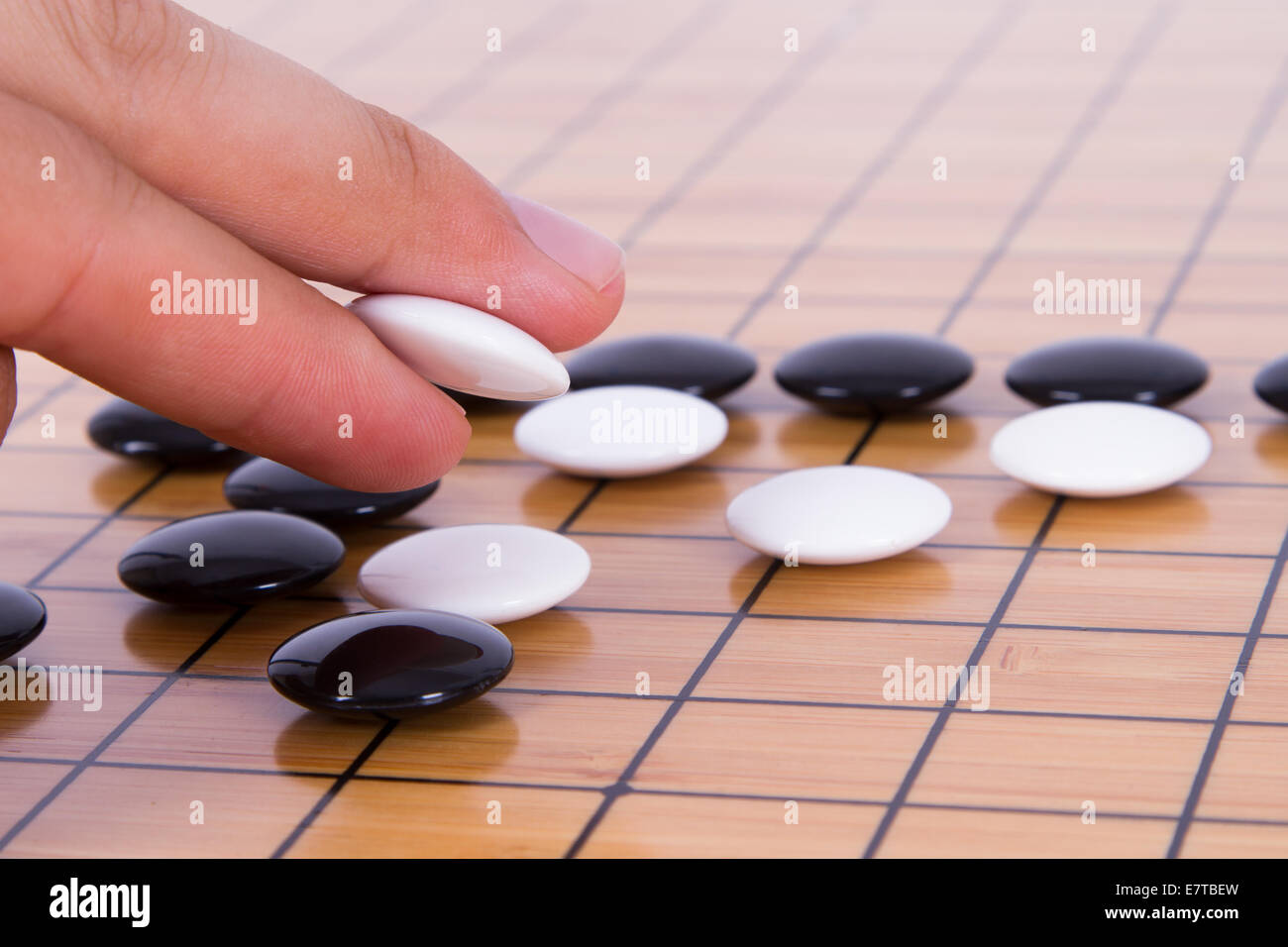 Close up view of hand playing black and white stone pieces on Chinese ...