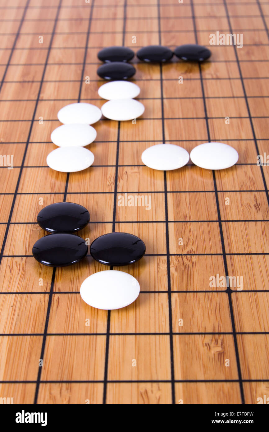 Close up view of black and white stone pieces on Chinese go game board ...