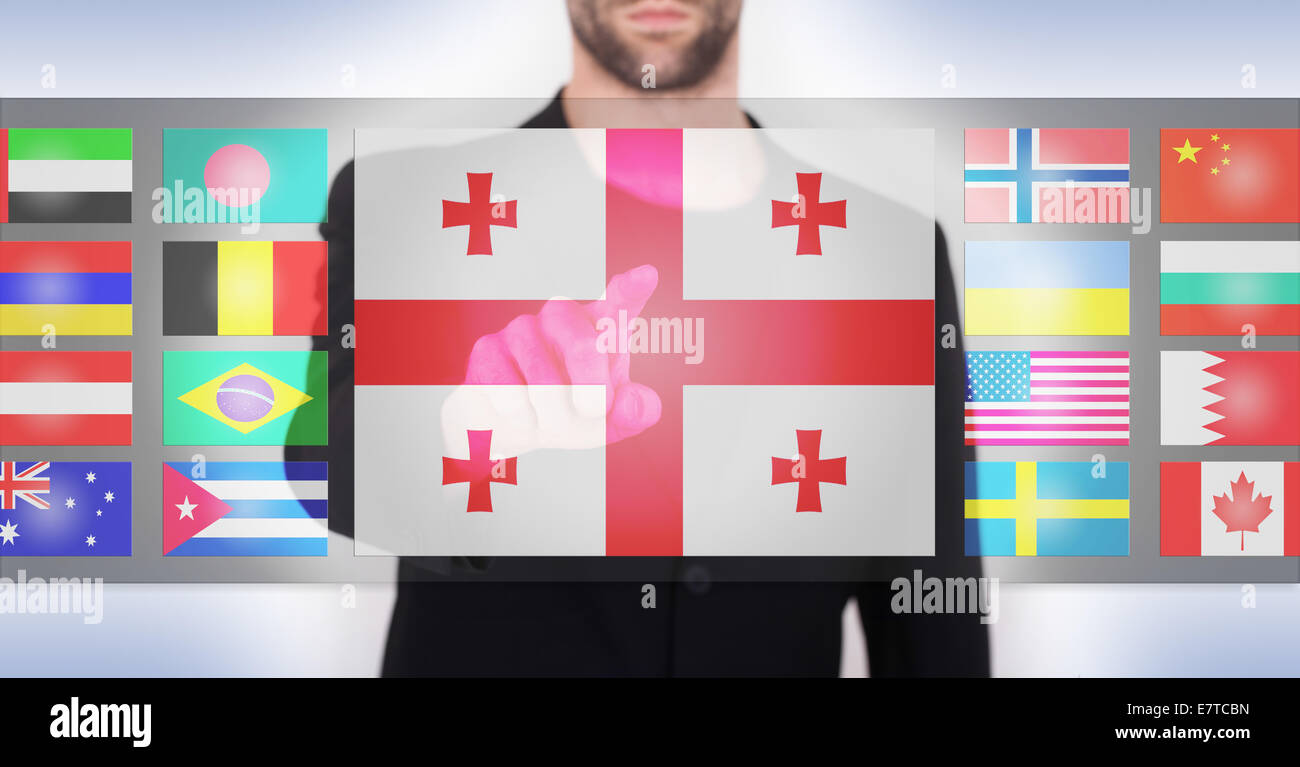 Hand pushing on a touch screen interface, choosing language or country ...