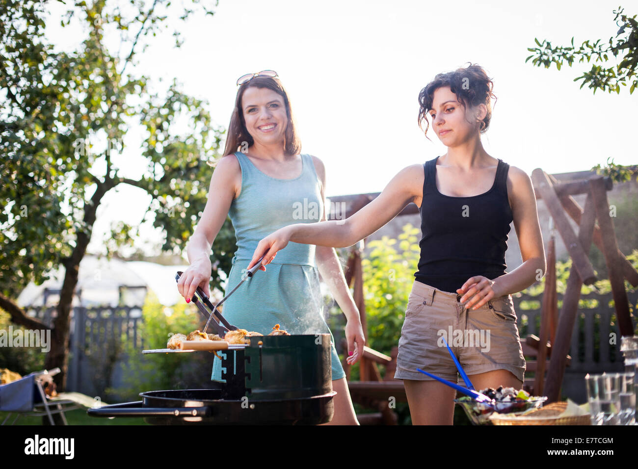 Two pretty girls making food on grill Stock Photo - Alamy