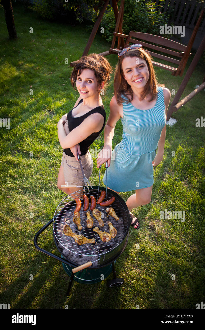 Two pretty girls making food on grill Stock Photo - Alamy