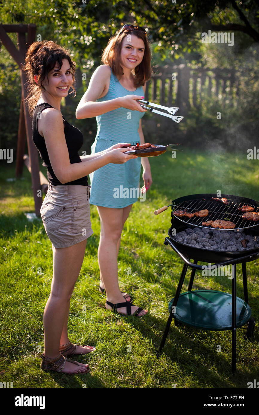 Two pretty girls making food on grill Stock Photo - Alamy