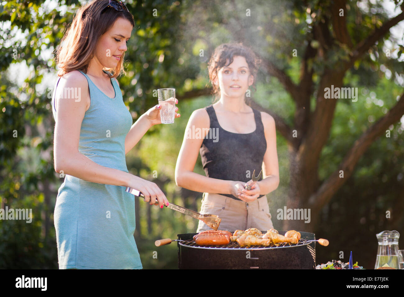 Two pretty girls making food on grill Stock Photo - Alamy
