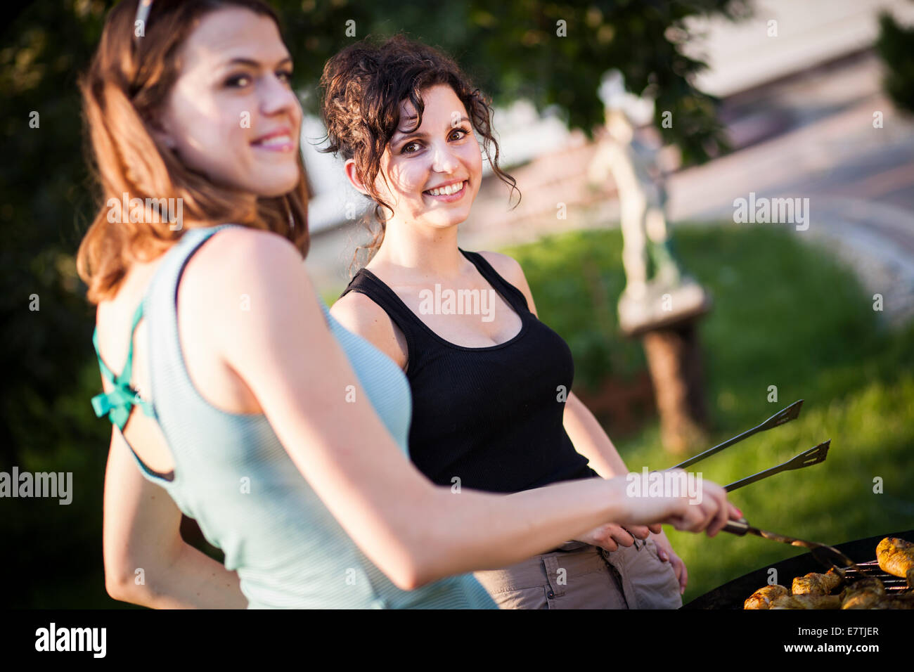 Two pretty girls making food on grill Stock Photo - Alamy