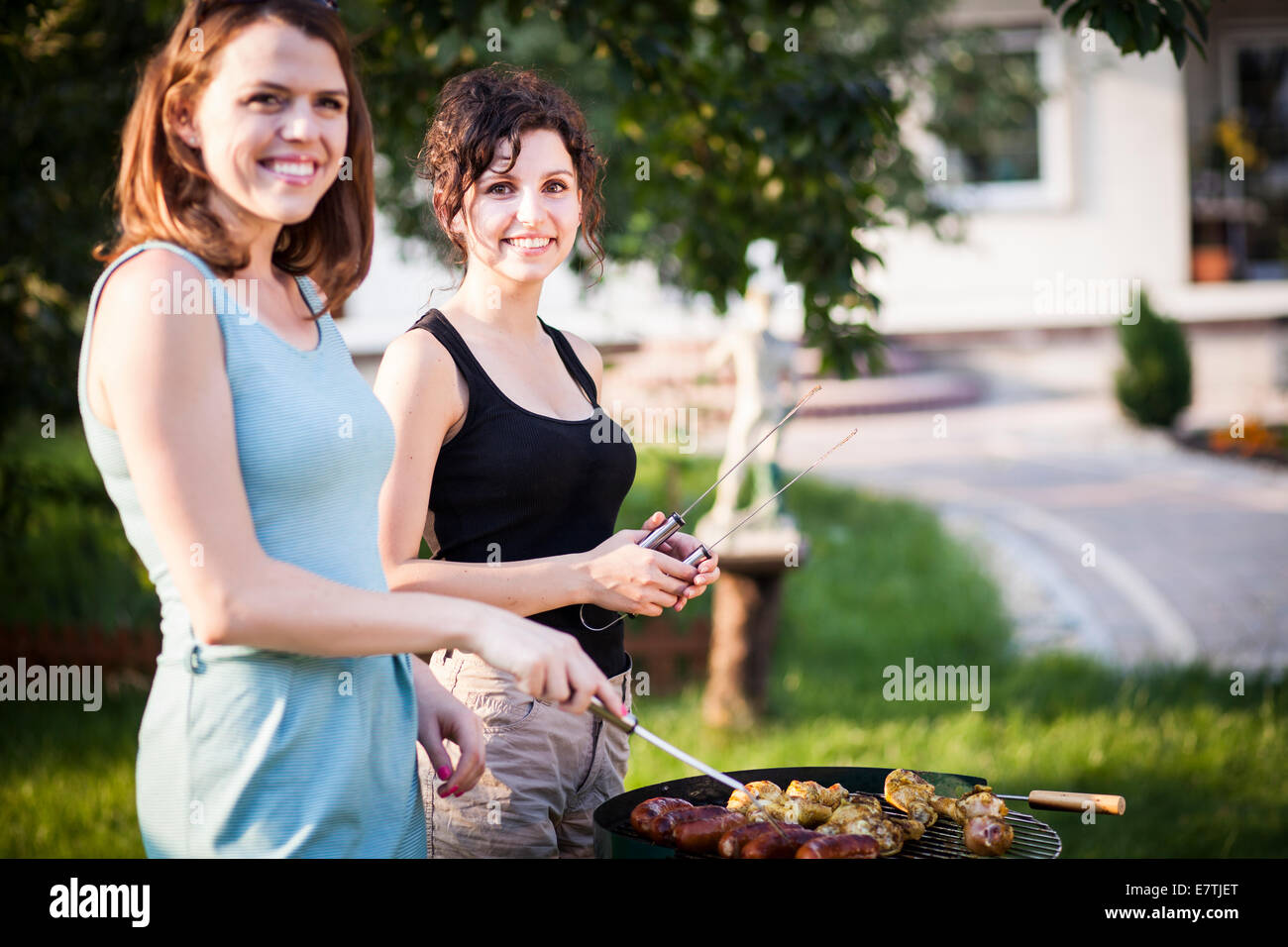 Two pretty girls making food on grill Stock Photo - Alamy