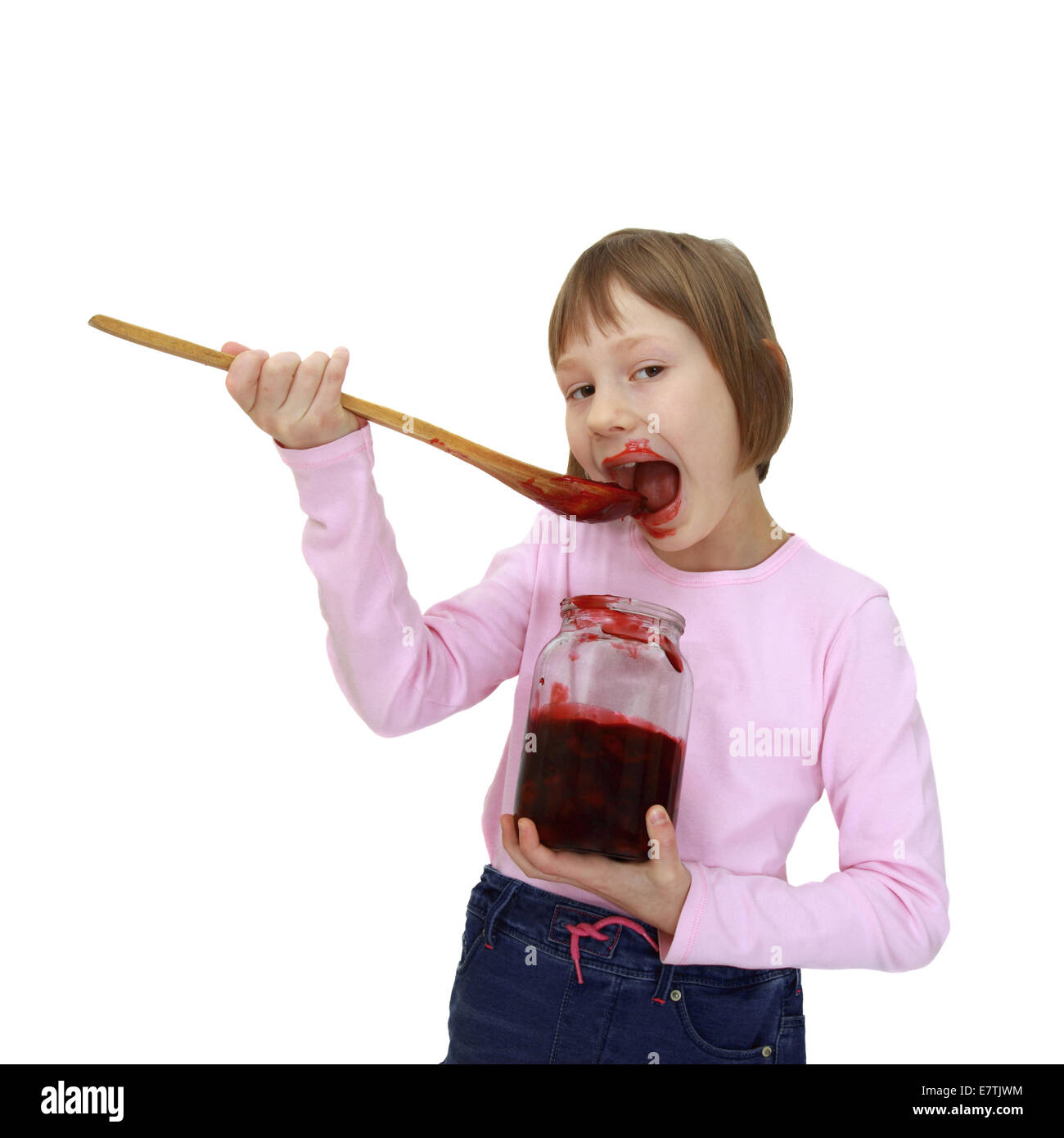 Girl eats jam from jar using a big wooden spoon isolated on white ...