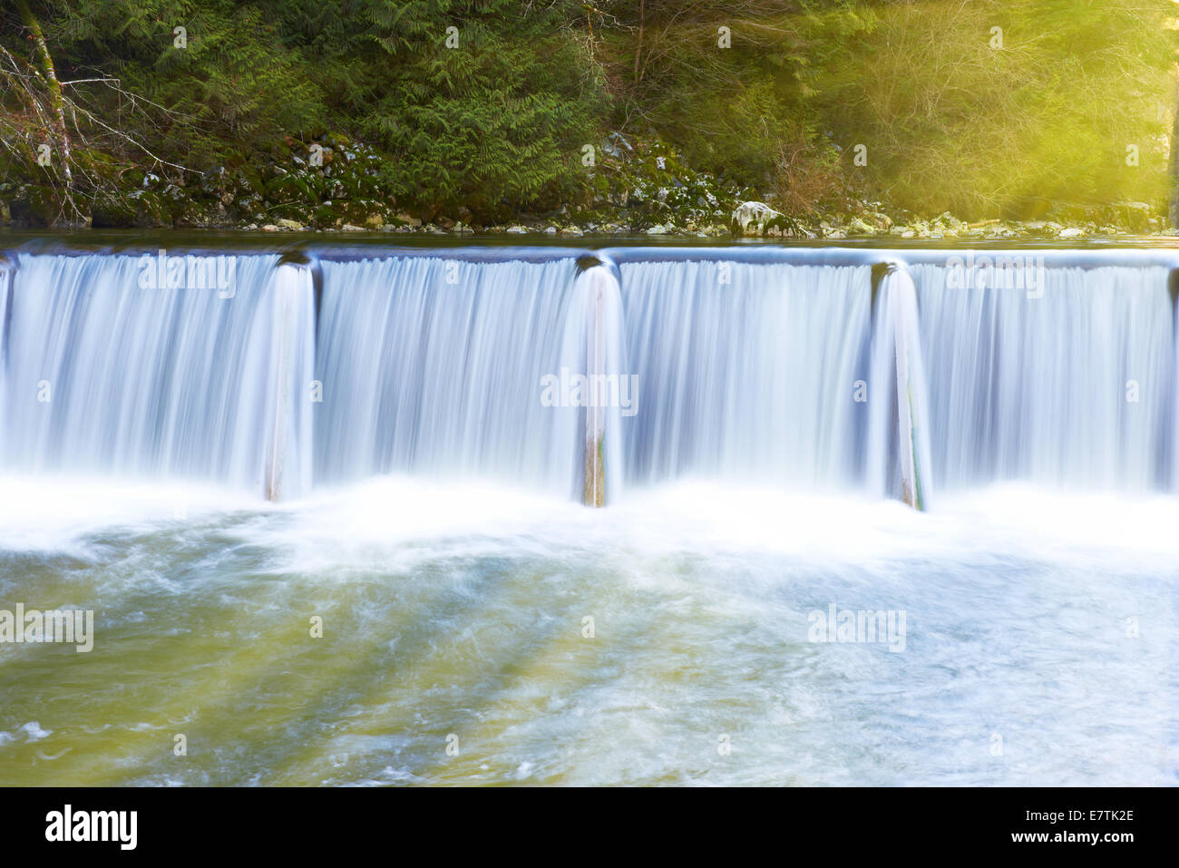 Sunny waterfall cascade streaming down in the green forest Stock Photo ...