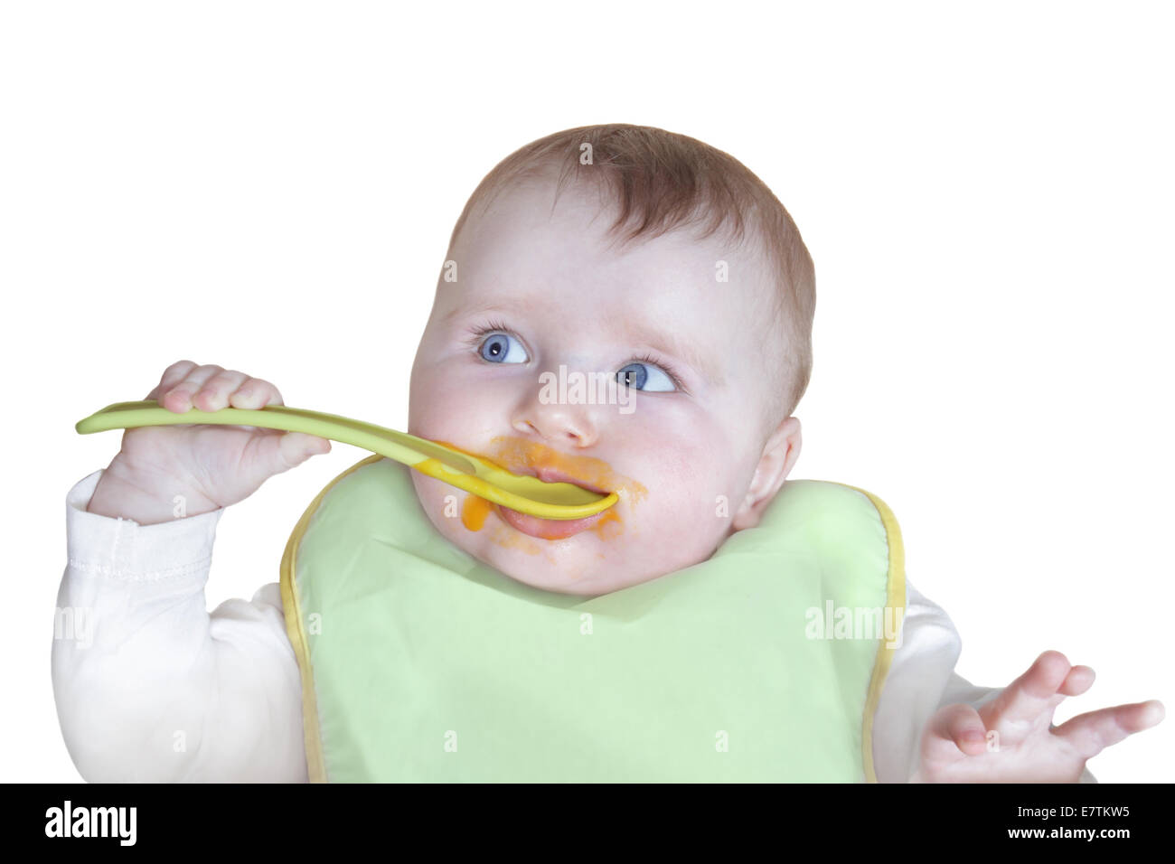 Infant eats yellow puree with spoon isolated on white background Stock ...
