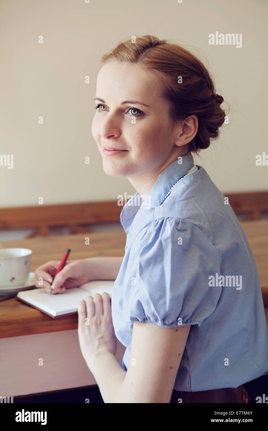 Retro style woman writing in the diary Stock Photo - Alamy