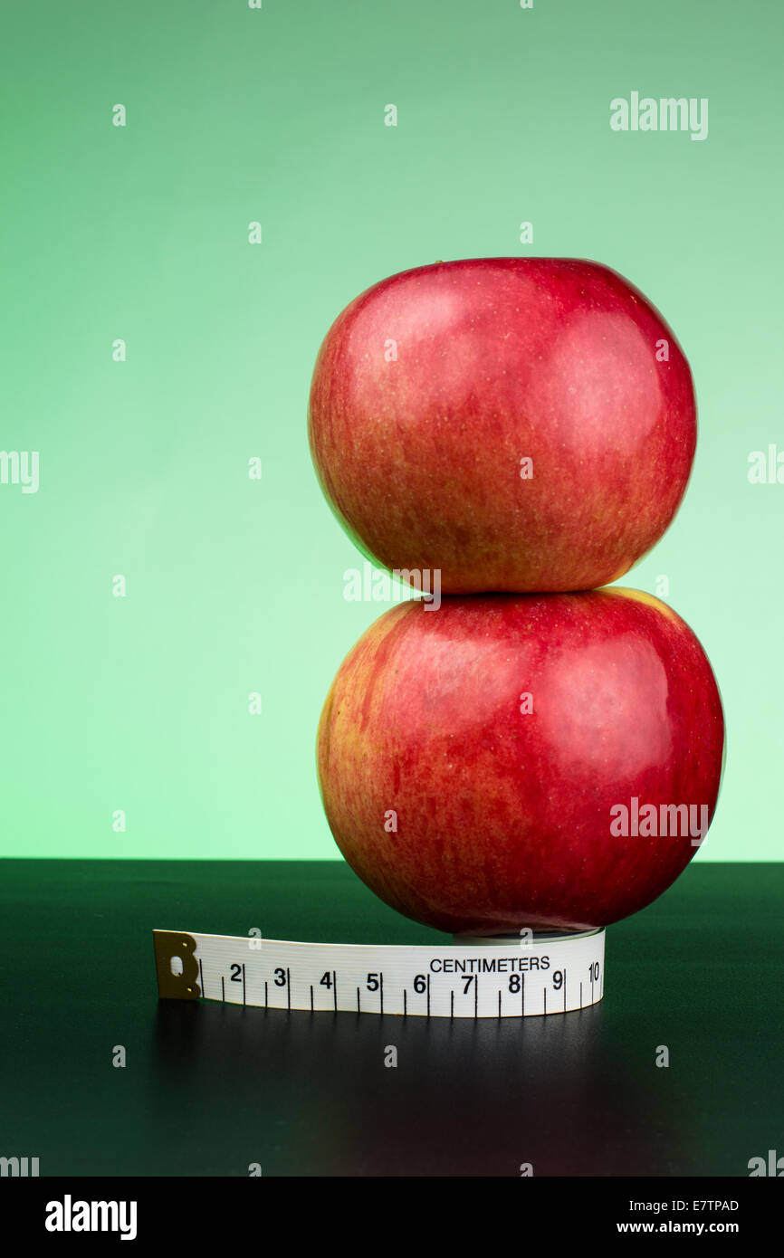 Apples with green measure tape on white background Stock Photo - Alamy