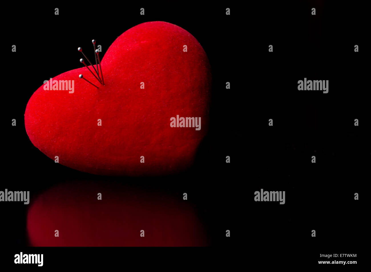 Red heart with pins on dark background Stock Photo - Alamy
