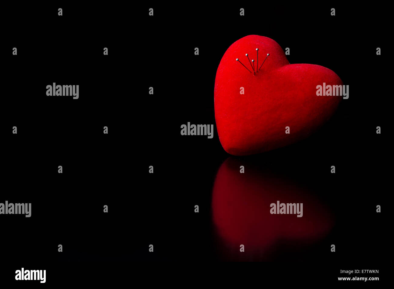 Red heart with pins on dark background Stock Photo - Alamy