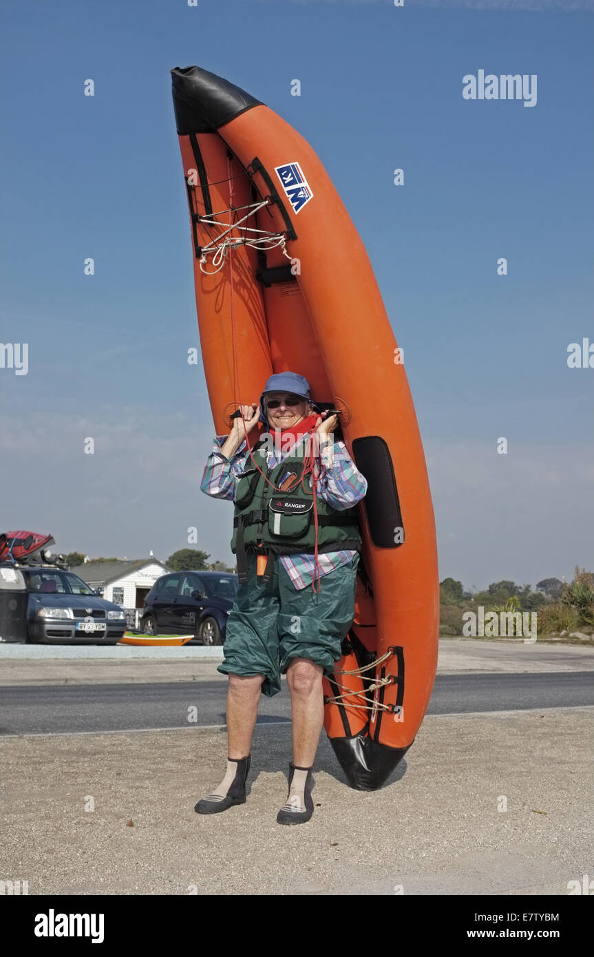 A lady in her early 70's carries her dinghy to the sea Stock Photo - Alamy