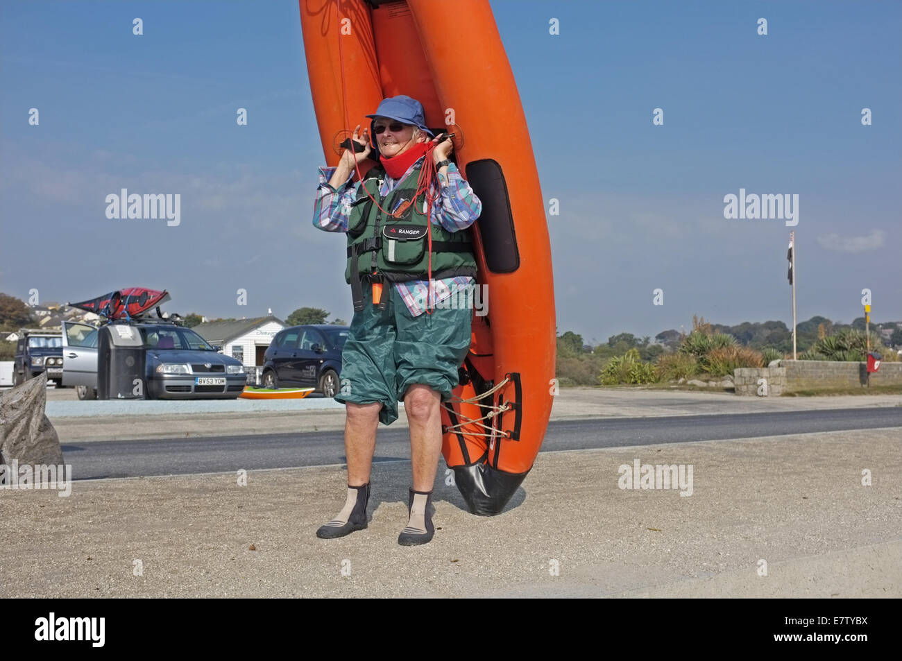 A lady in her early 70's carries her dinghy to the sea Stock Photo - Alamy