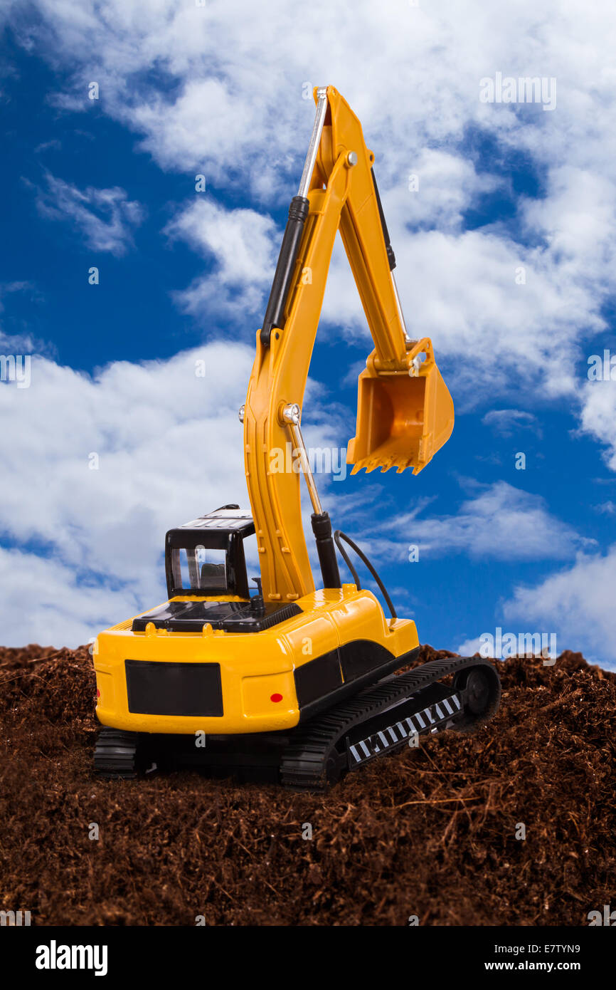Construction machine, excavator on pile of soil digging a trench ...