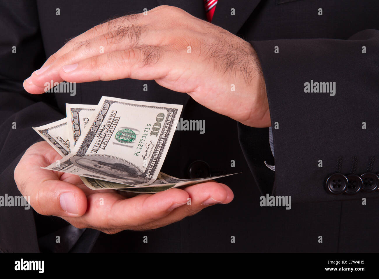 Businessman protecting, saving money between two hands Stock Photo - Alamy