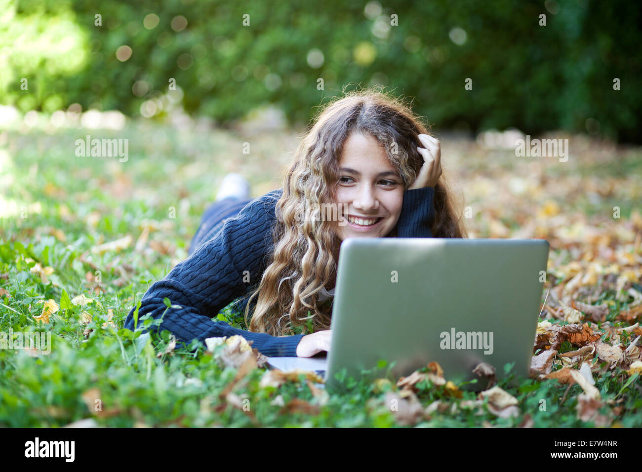 Teenager female girl student with laptop outdoor in the garden with ...