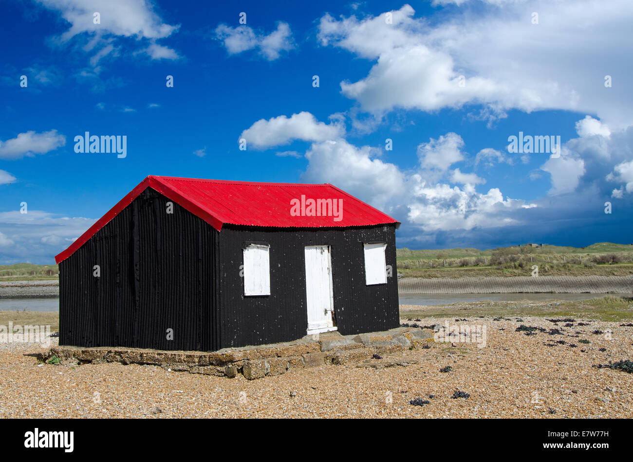 Black white and red hut near Rye Harbour, England. Beautiful blue sky ...