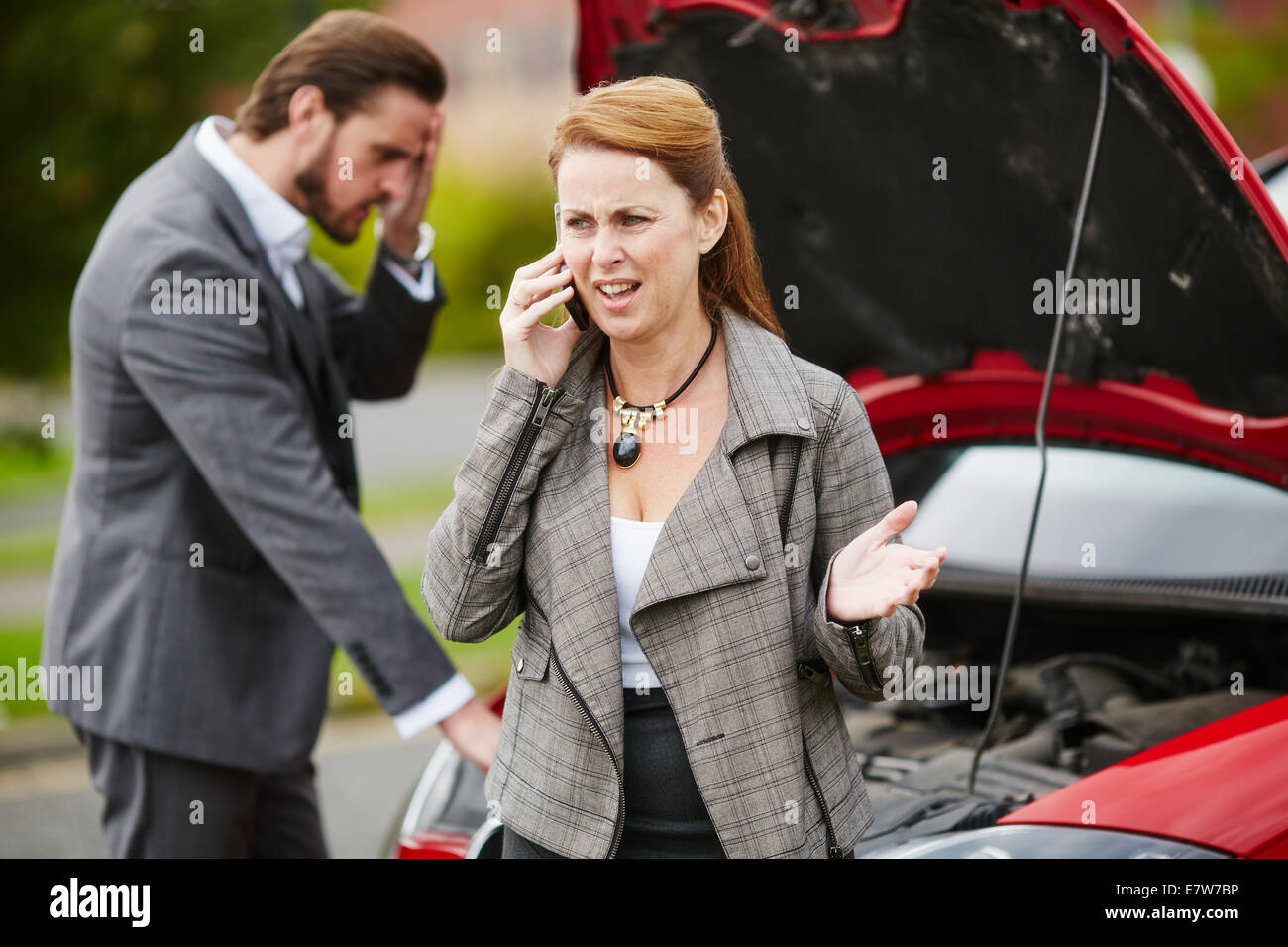 Couple with broken down car Stock Photo - Alamy