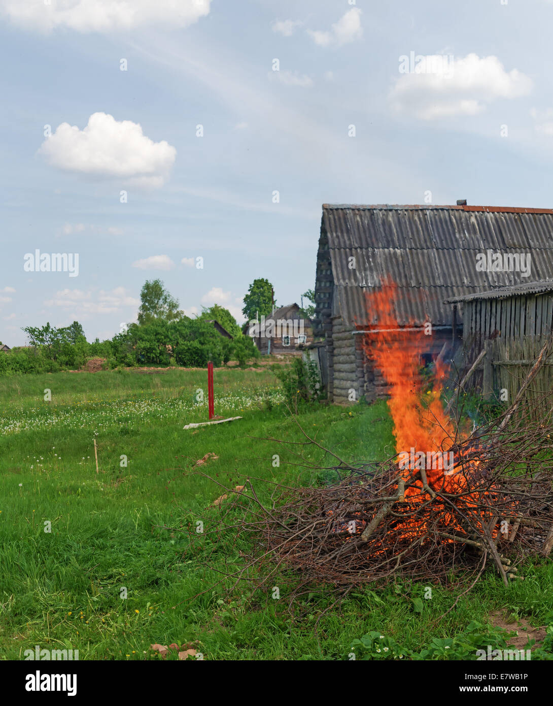 The old house in the village. Fire in the field near the barn Stock ...