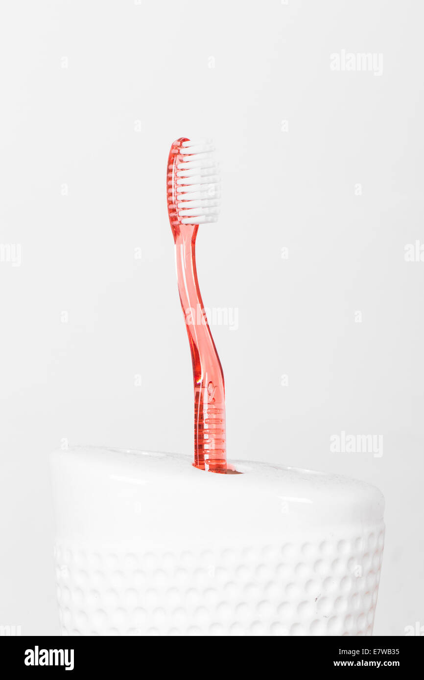 Single toothbrush with red plastic body, isolated on white background ...