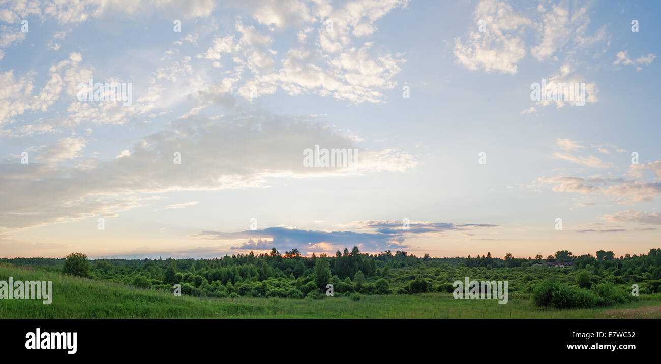 Sunset over field and forest Stock Photo - Alamy