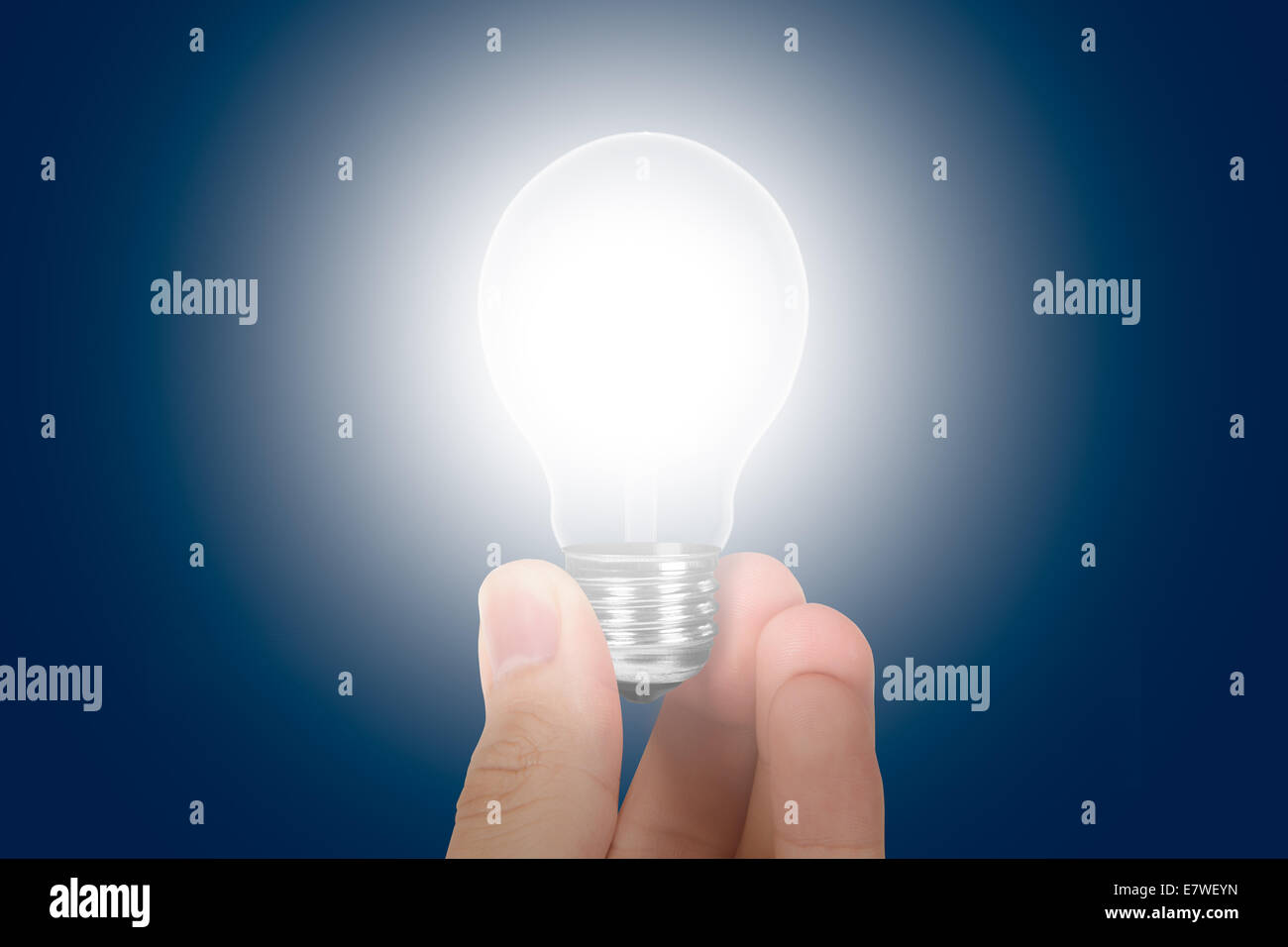 Hand holding glowing light bulb with blue background Stock Photo - Alamy