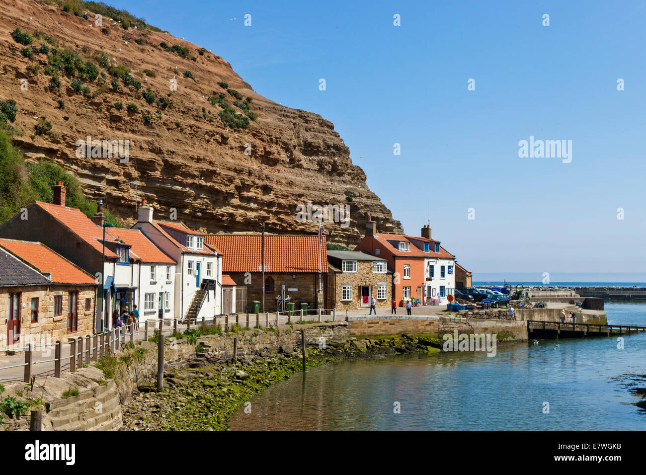 Cowbar Nab and Roxby Beck in bright sunlight in the village of Staithes ...