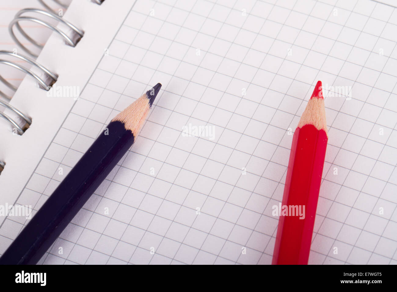 Purple and red pencils on blank, white, square lined ring binder ...
