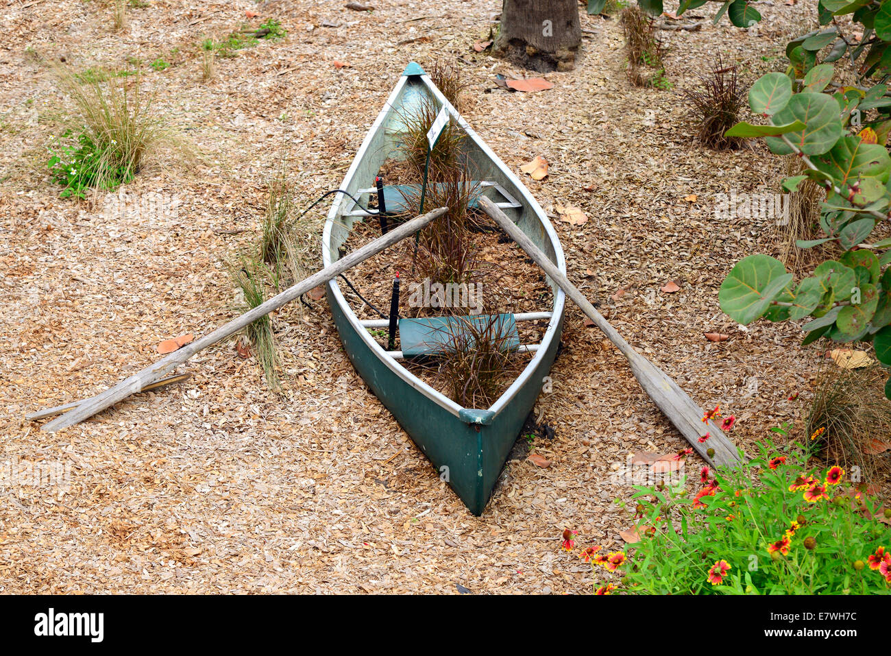 Small boat canoe used in a landscaping garden Stock Photo - Alamy