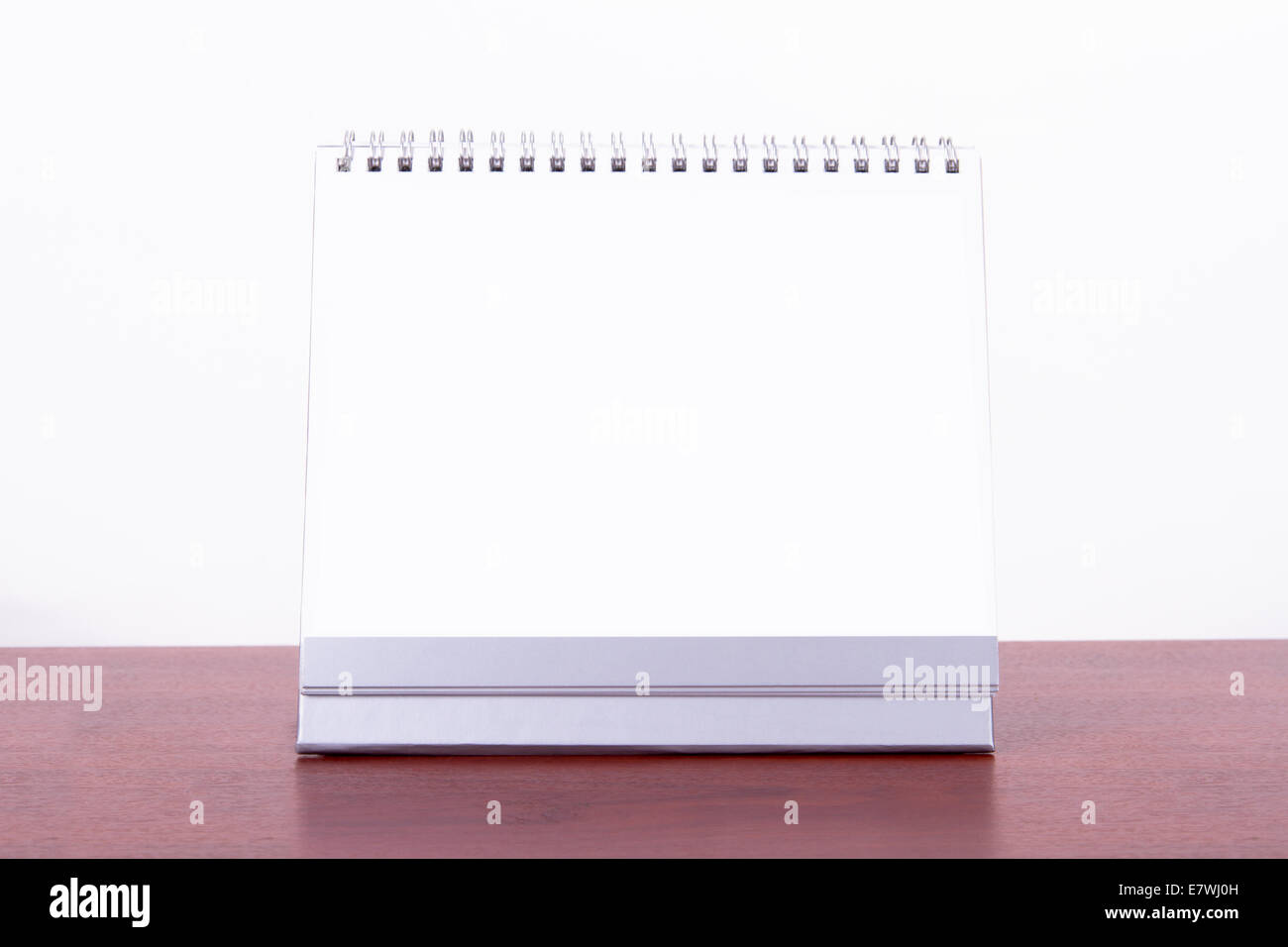 Single blank desk calendar on wooden table, isolated on white ...