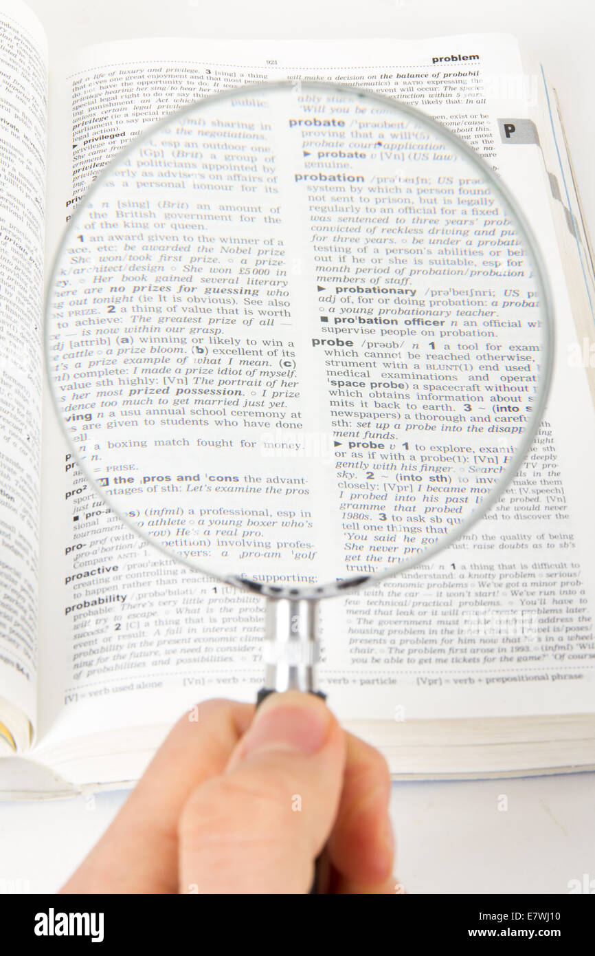 Hand holding classic style magnifying glass, searching for a word on ...