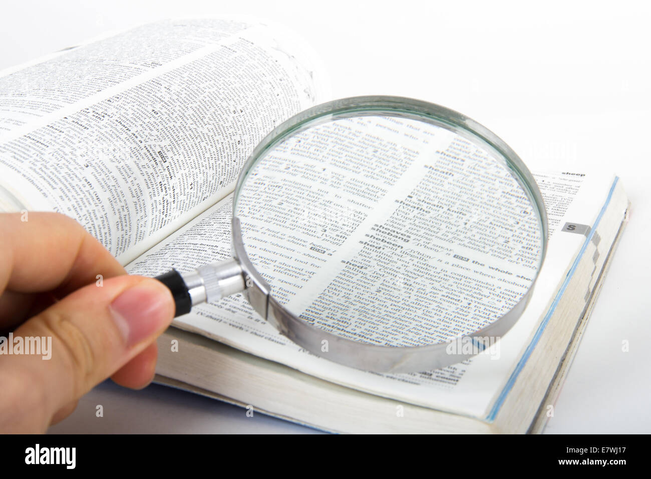 Hand holding classic style magnifying glass, searching for a word on ...
